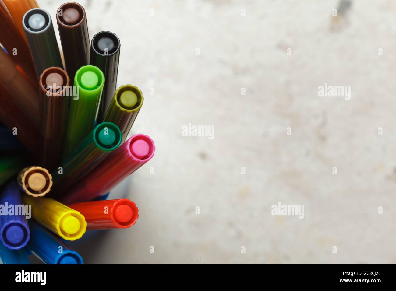 Set of markers in a plastic cup on stone background. Top view. concept ...