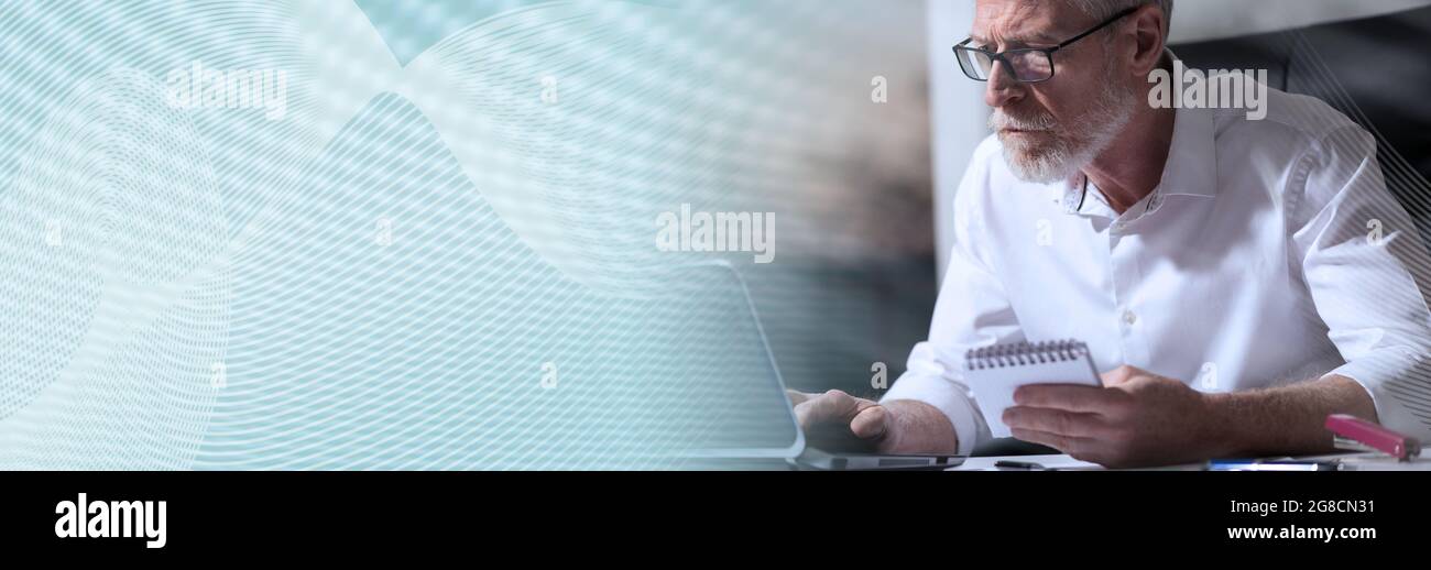 Senior businessman working on laptop in office, light effect, hard ...