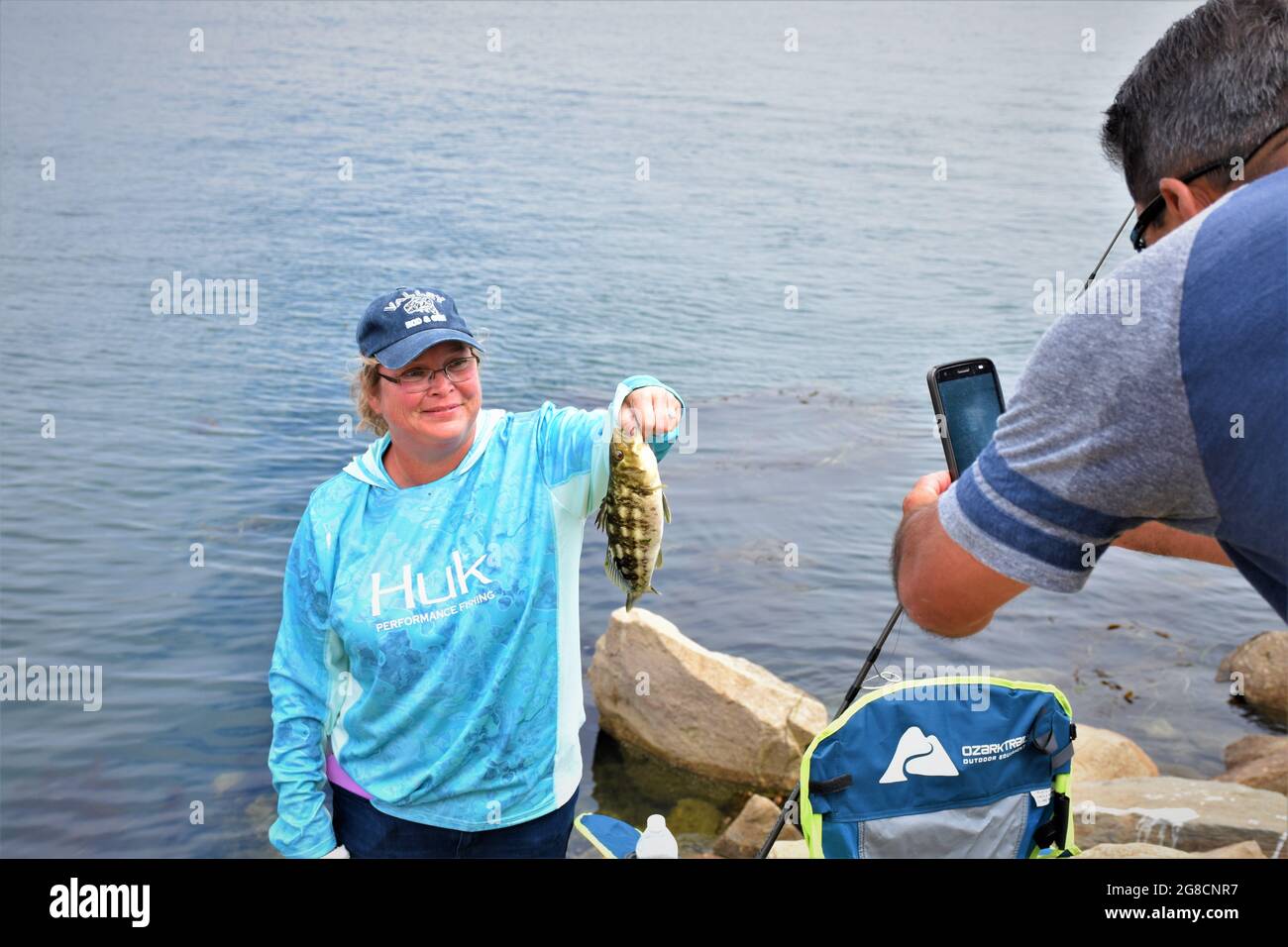 Woman shows the catch of her own to her son who is having a fine time ...
