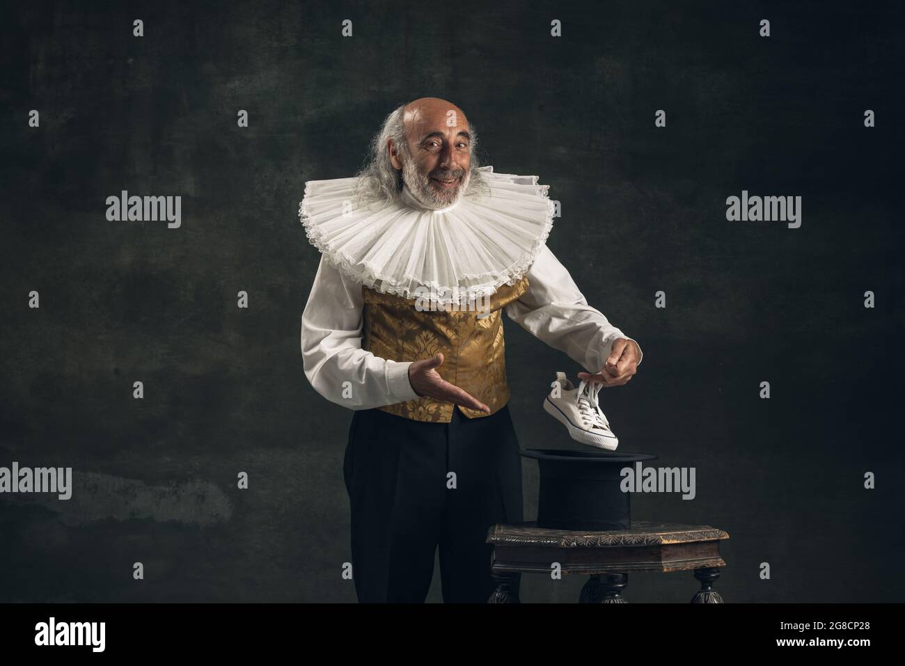 Elderly gray-haired man, actor or magician isolated on dark vintage ...