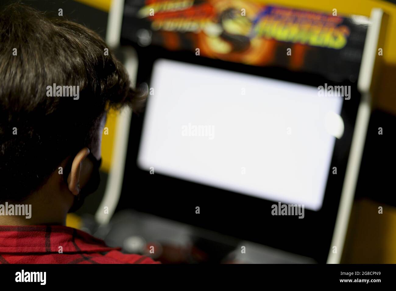 Boy playing old arcade Stock Photo - Alamy