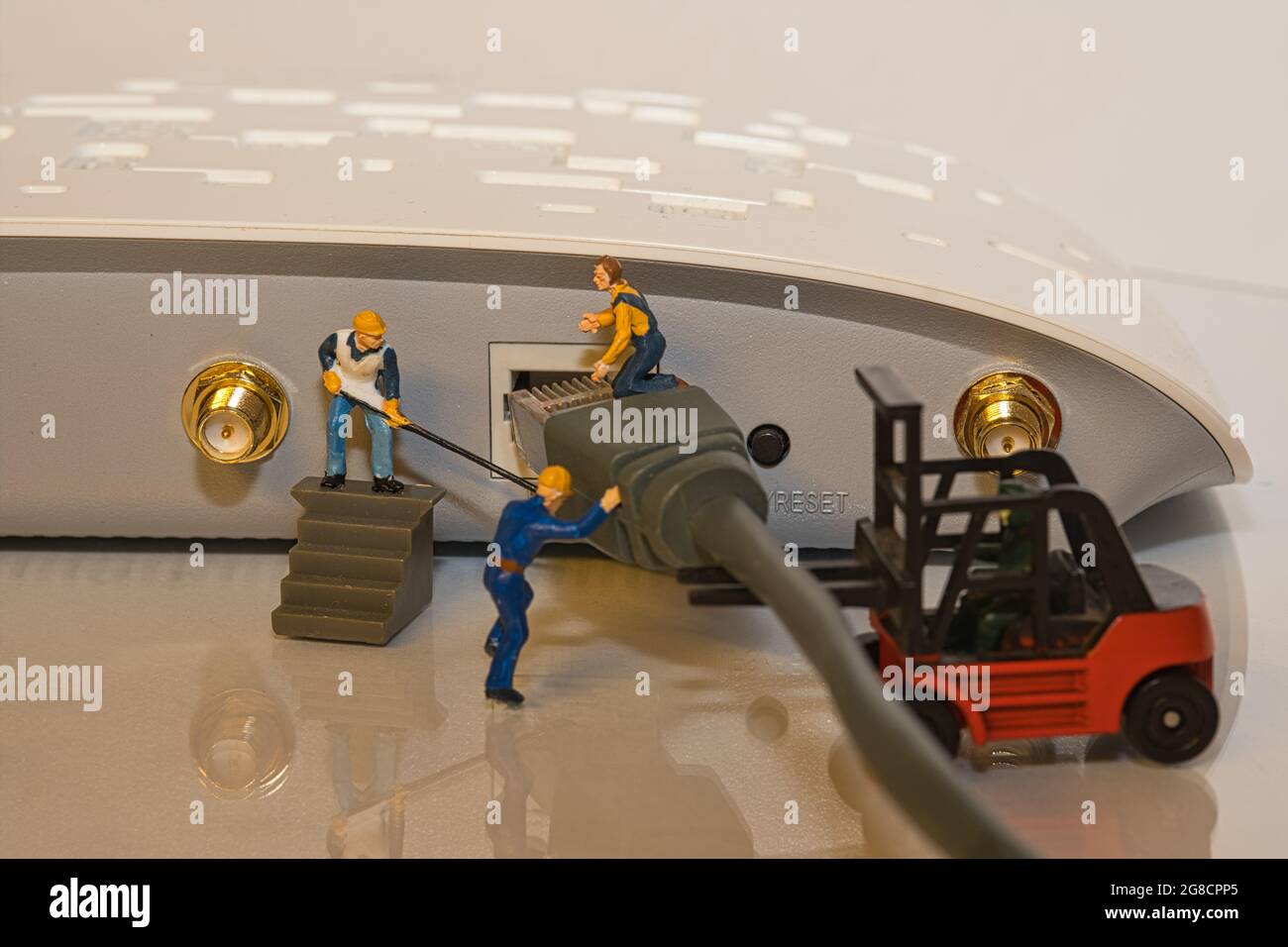 Team of miniature figures connects a data cable in an internet router ...