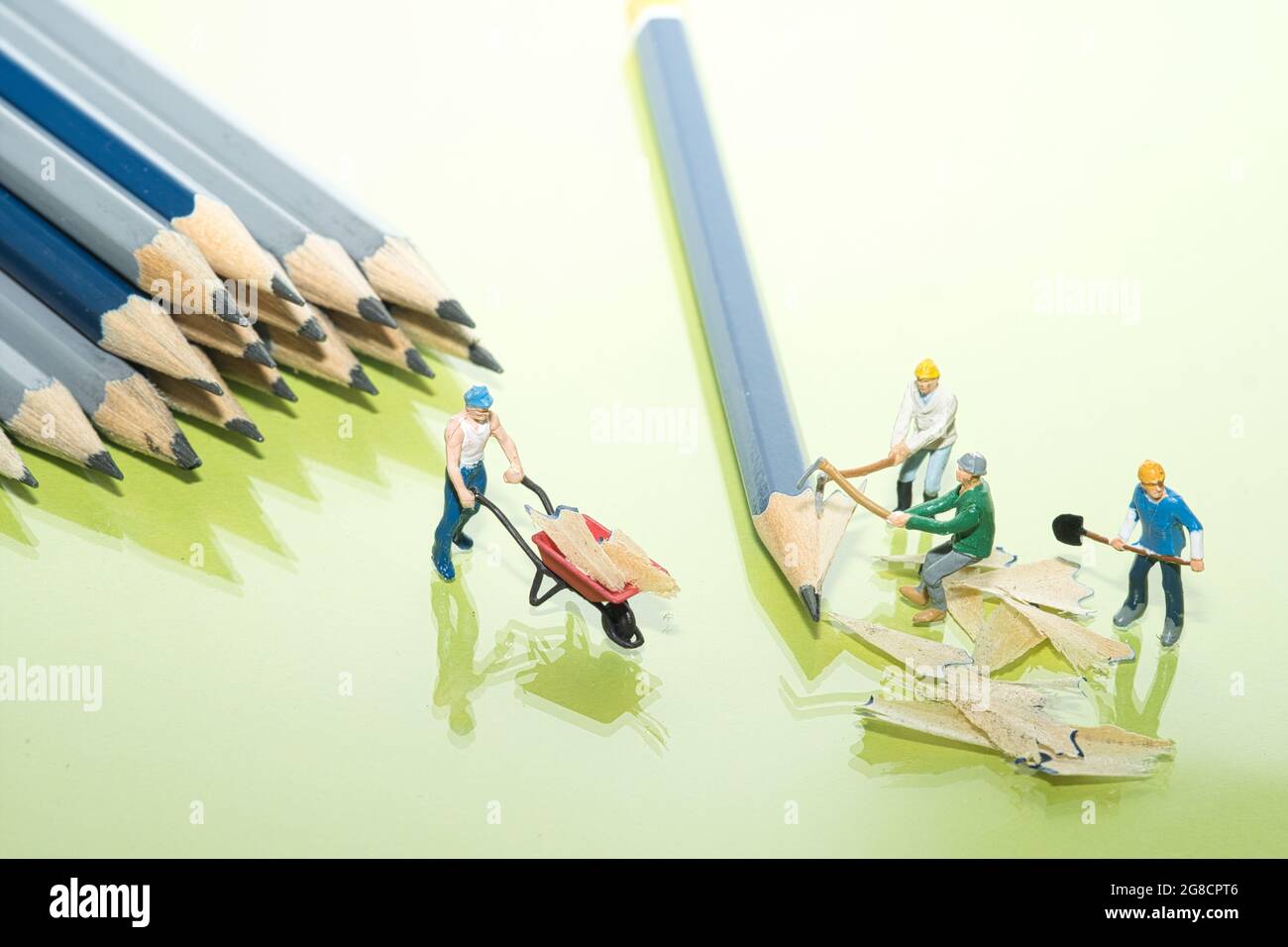 Miniature workers sharpen a pencil with a pickaxe Stock Photo - Alamy