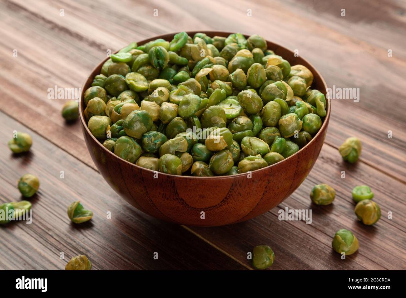 Salted green peas in wooden bowl on the table, Healthy snack ...