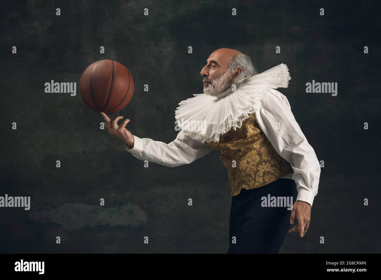 One old man, actor having fun, playing with basketball ball isolated on ...