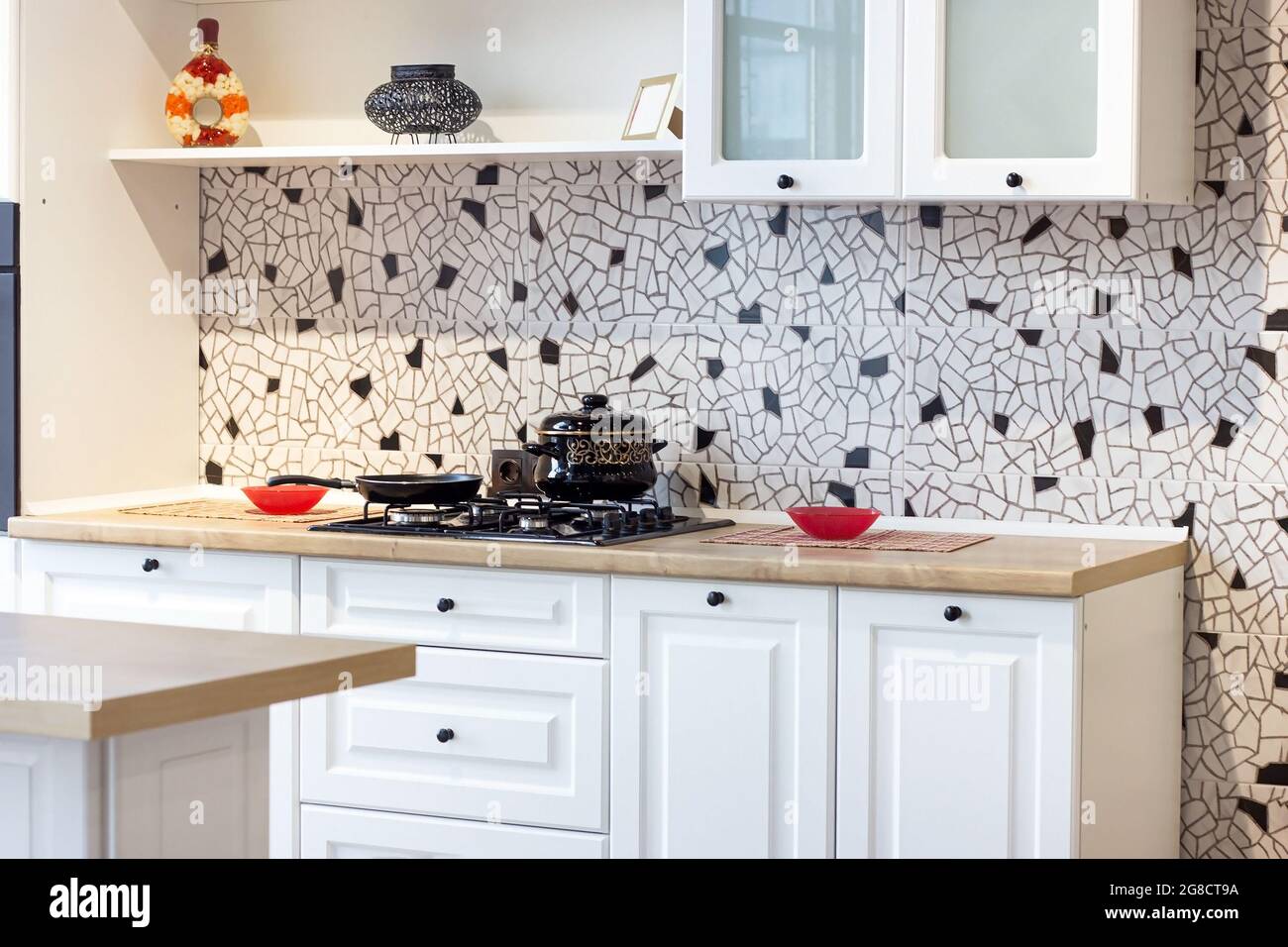 New modern domestic kitchen with the wooden table and stove with pans ...