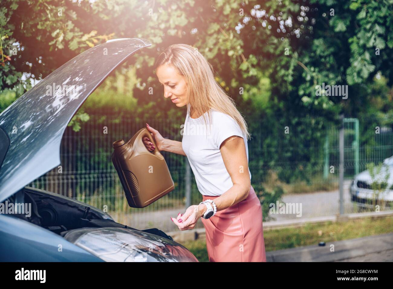A woman is holding a bottle of motor oil in her car Stock Photo - Alamy