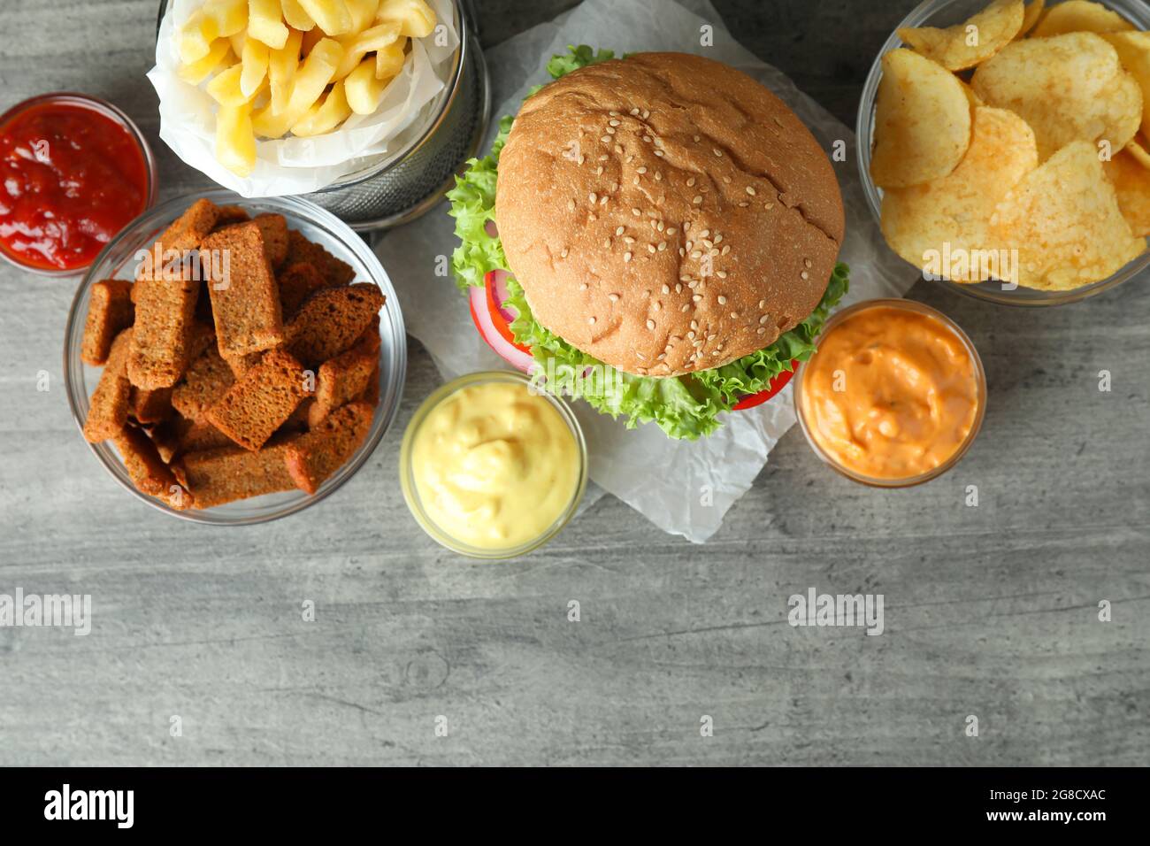 Tasty fast food on gray textured table Stock Photo - Alamy