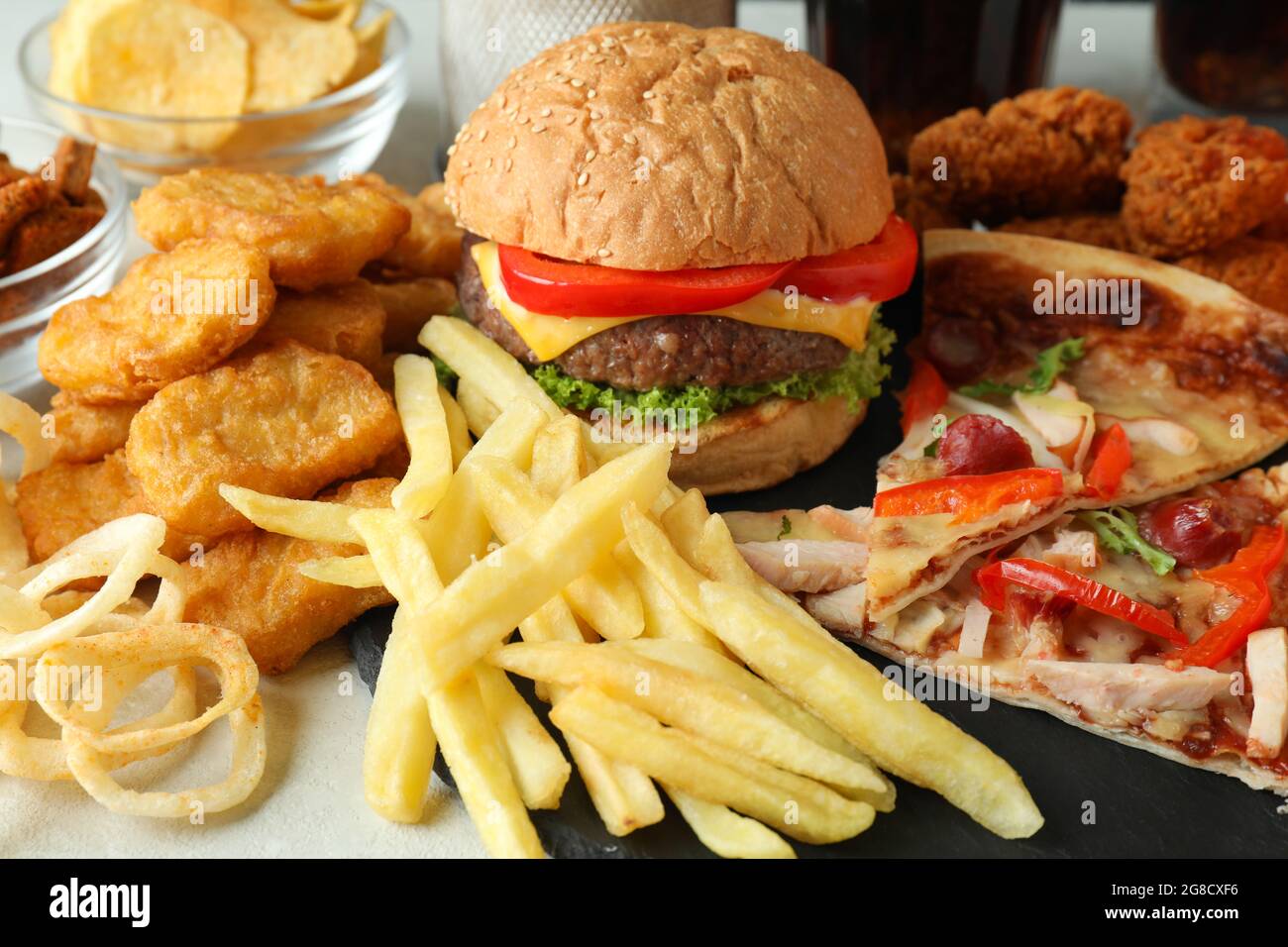 Concept of fast food on white textured table Stock Photo - Alamy