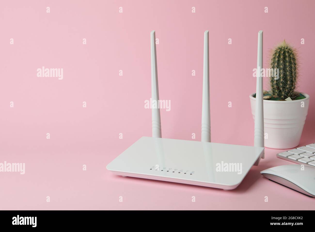 Workplace with Wi - fi router on pink background Stock Photo - Alamy