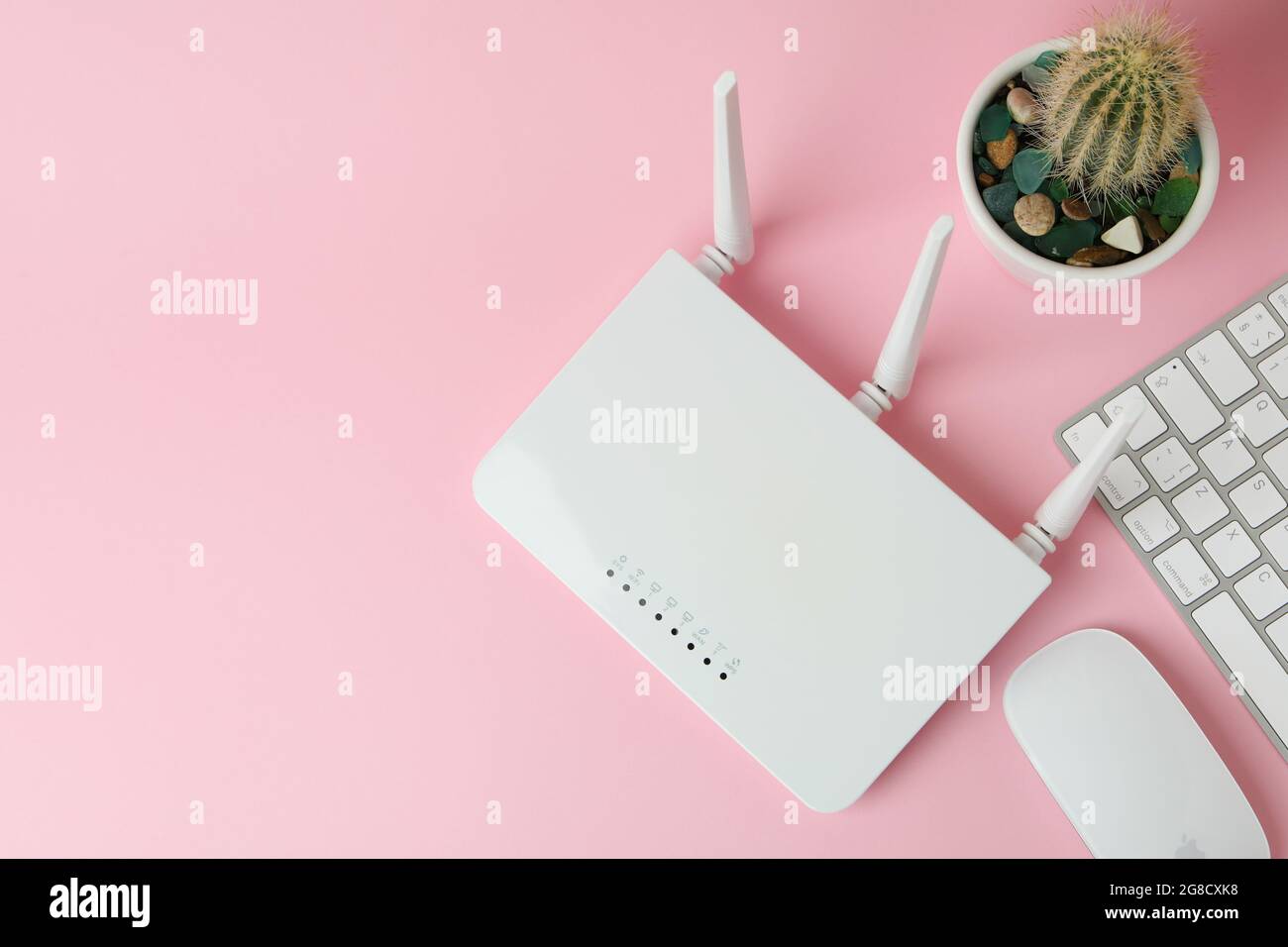 Workplace with Wi - fi router on pink background Stock Photo - Alamy