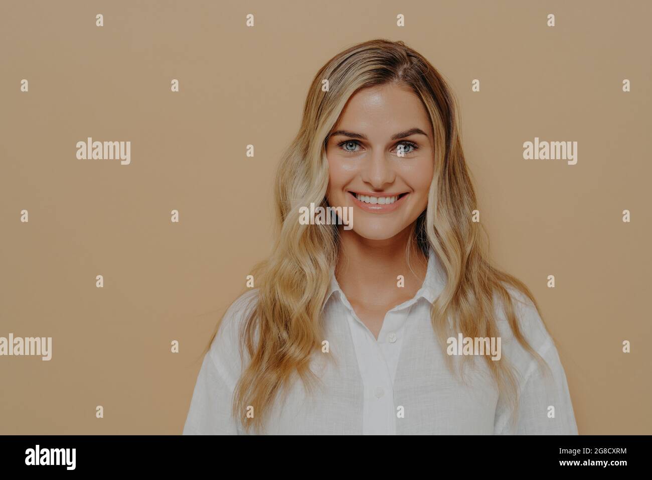 Calm blonde teenage girl smiling and looking straight at camera Stock ...