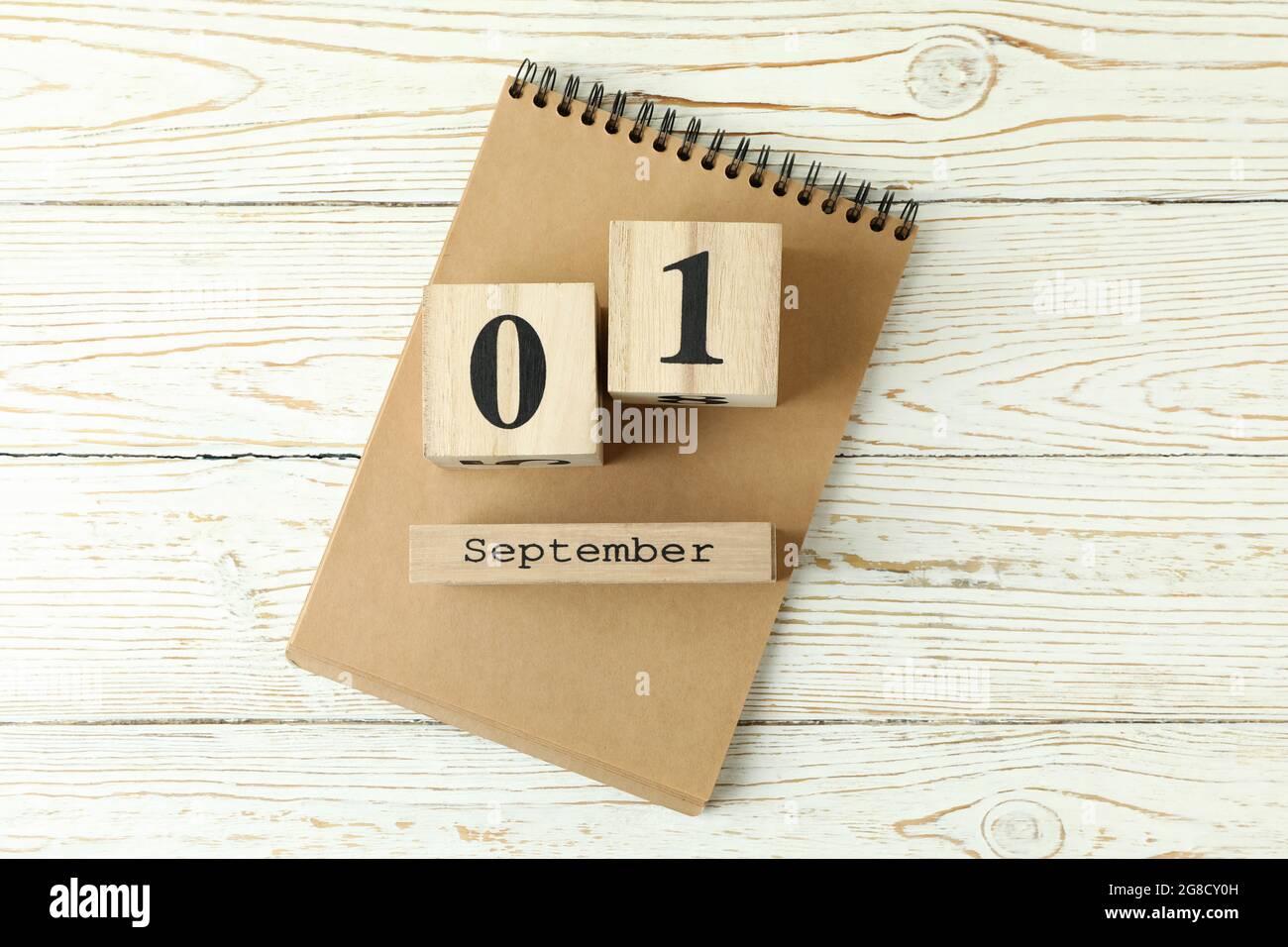 Notebook and wooden calendar with September 1 on white wooden ...