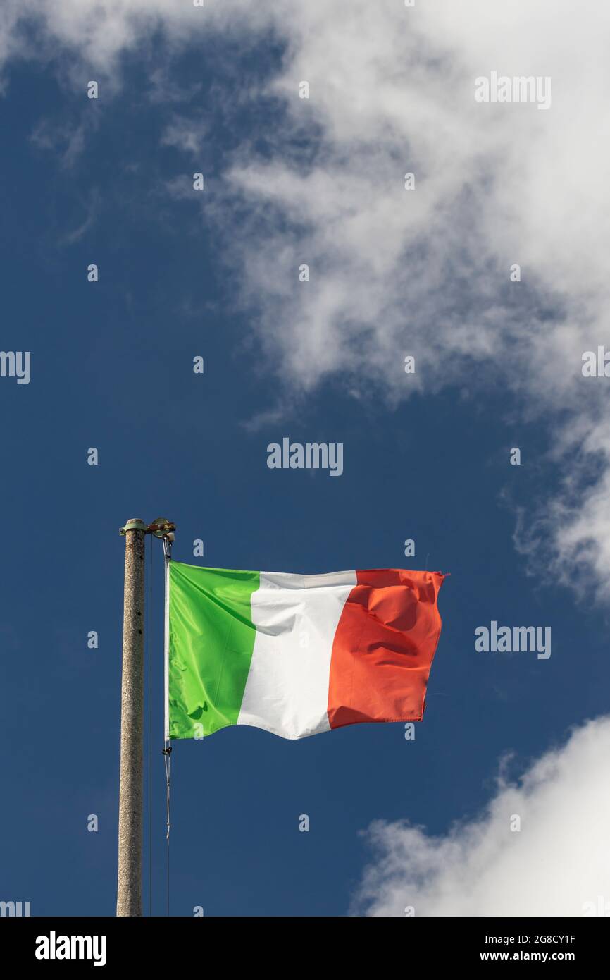 Italian flag blowing in the wind in the blue sky Stock Photo - Alamy
