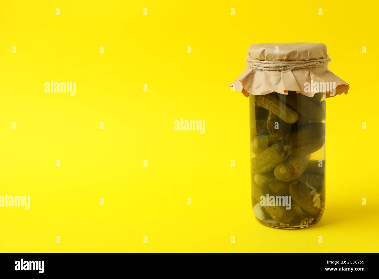 Jar with craft paper of pickles on yellow background Stock Photo - Alamy