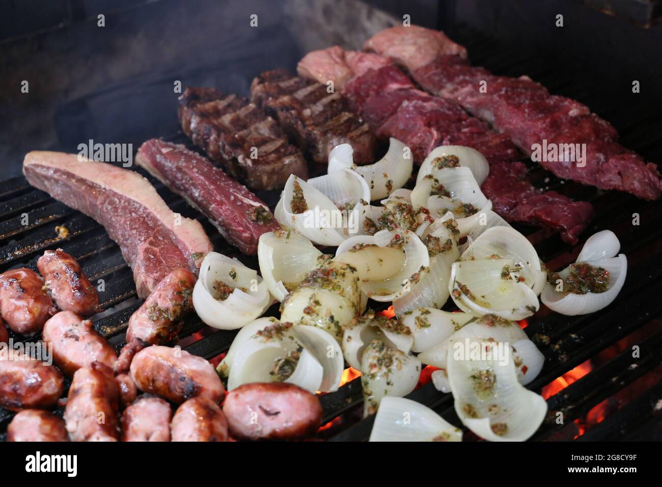 grill full of meats, sausages, onions, and steaks Stock Photo - Alamy