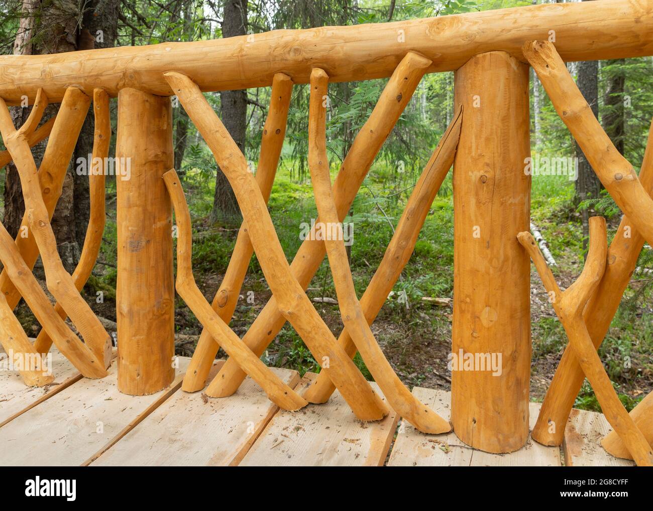 Decorative railings of a wooden footbridge in summer park, background ...