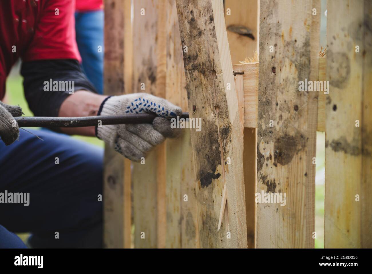 Working with wooden pallets. A man breaks a board in a pallet Stock ...