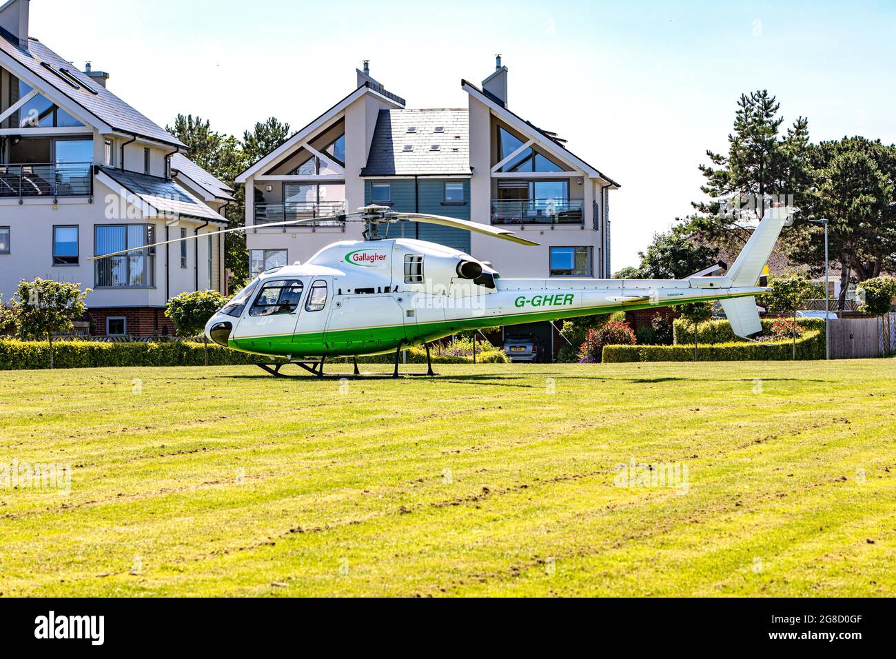 A helicopter landed on grassland near modern houses Stock Photo - Alamy