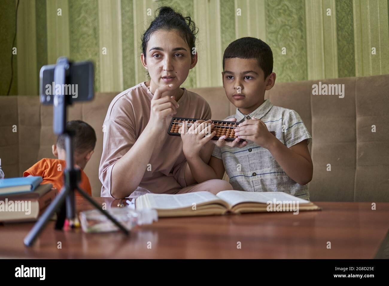 Young female teacher explaining the math lesson with a young pupil ...