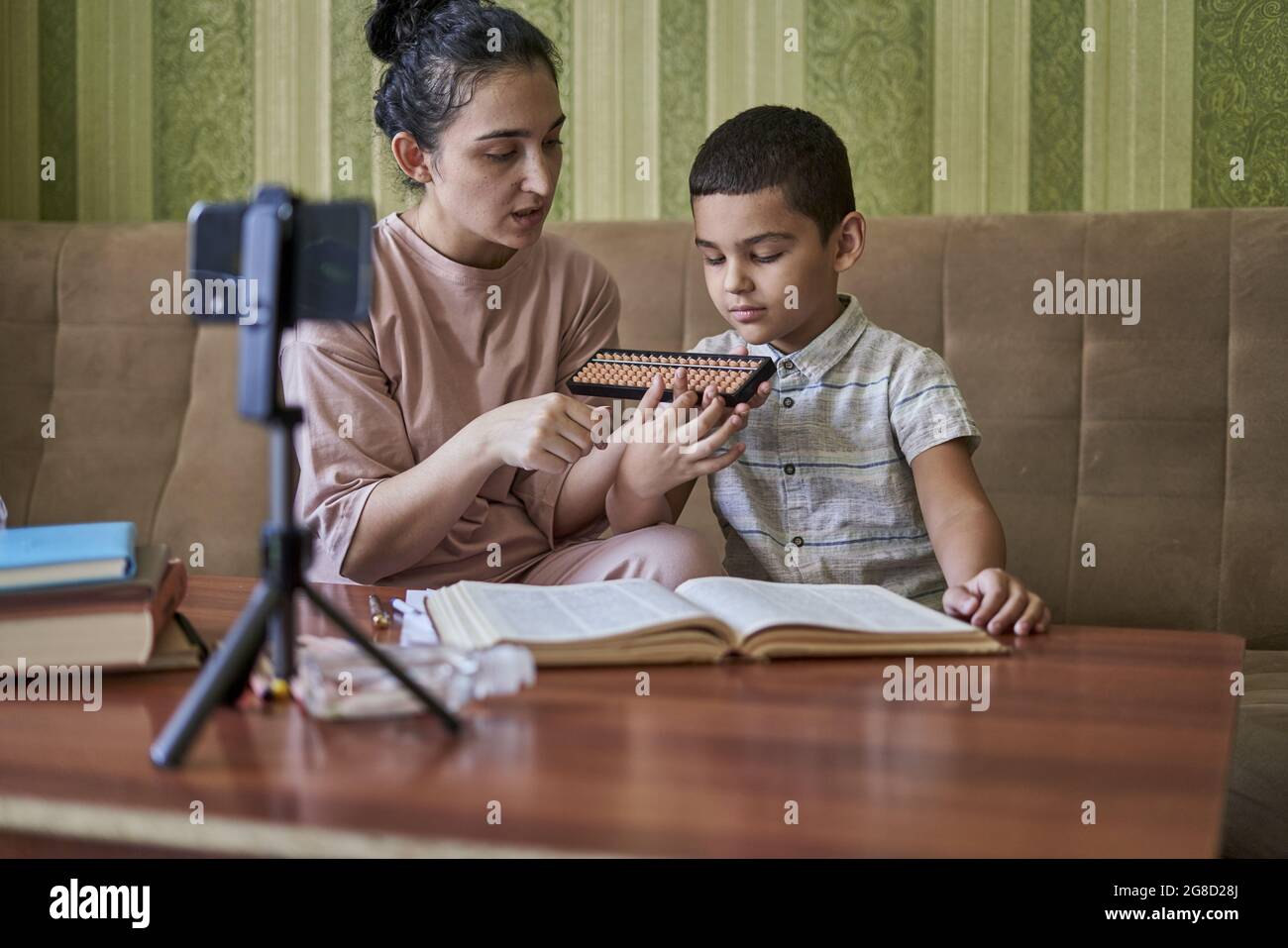 Young female teacher explaining the math lesson with a young pupil ...