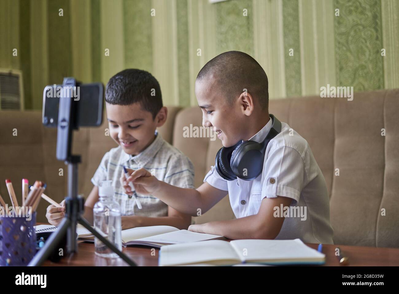 Young male pupils writing hi-res stock photography and images - Alamy