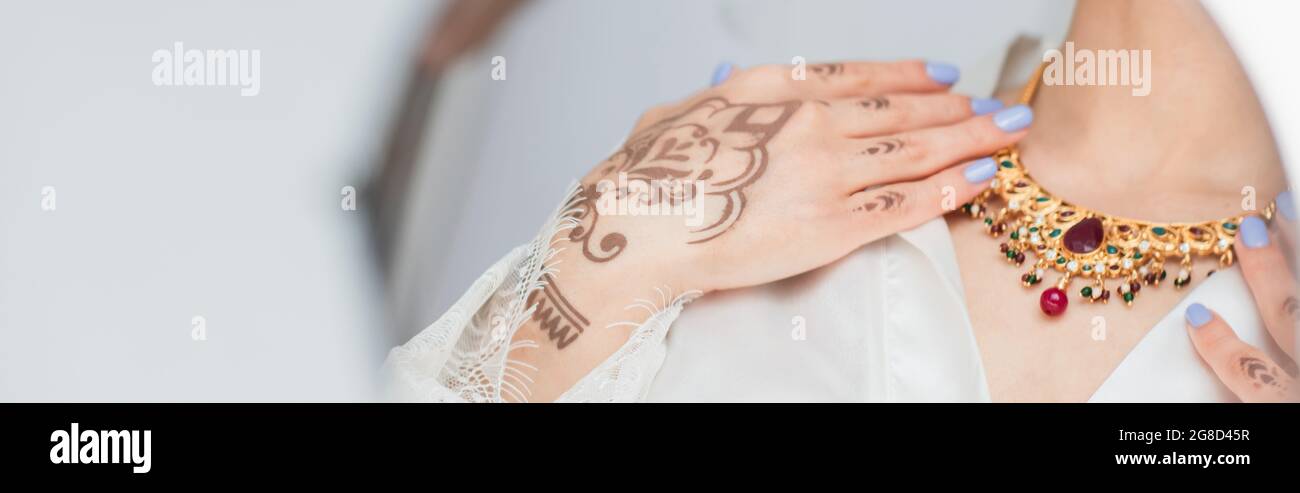 reflection in mirror of young indian bride wearing necklace on white ...