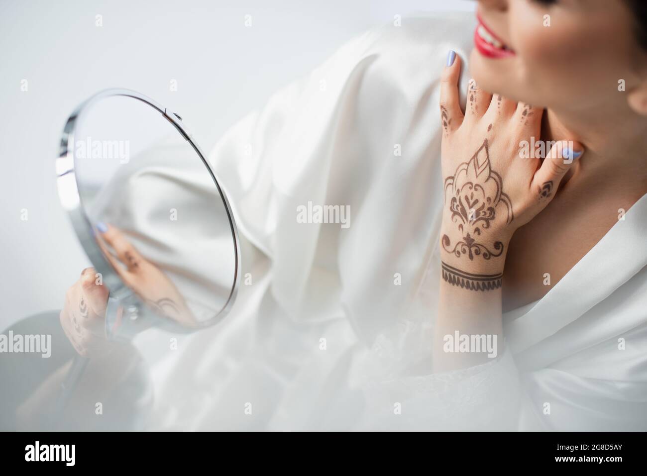 partial view of blurred and happy indian bride looking at mirror ...