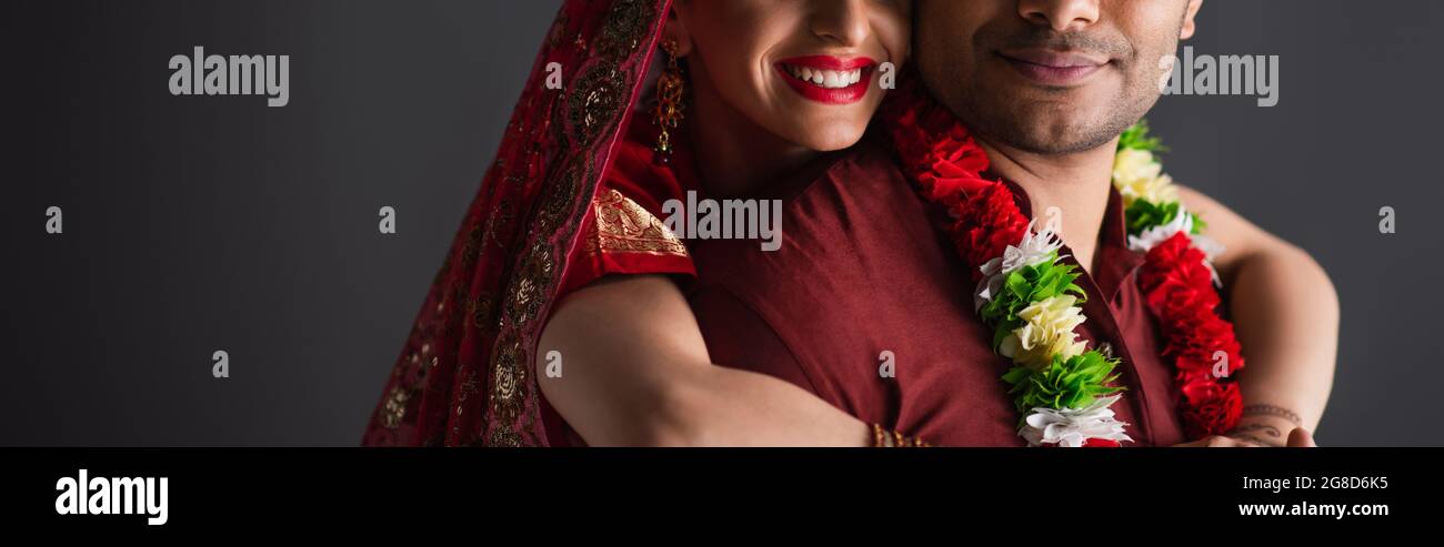 cropped view of cheerful indian bride hugging bridegroom isolated on ...