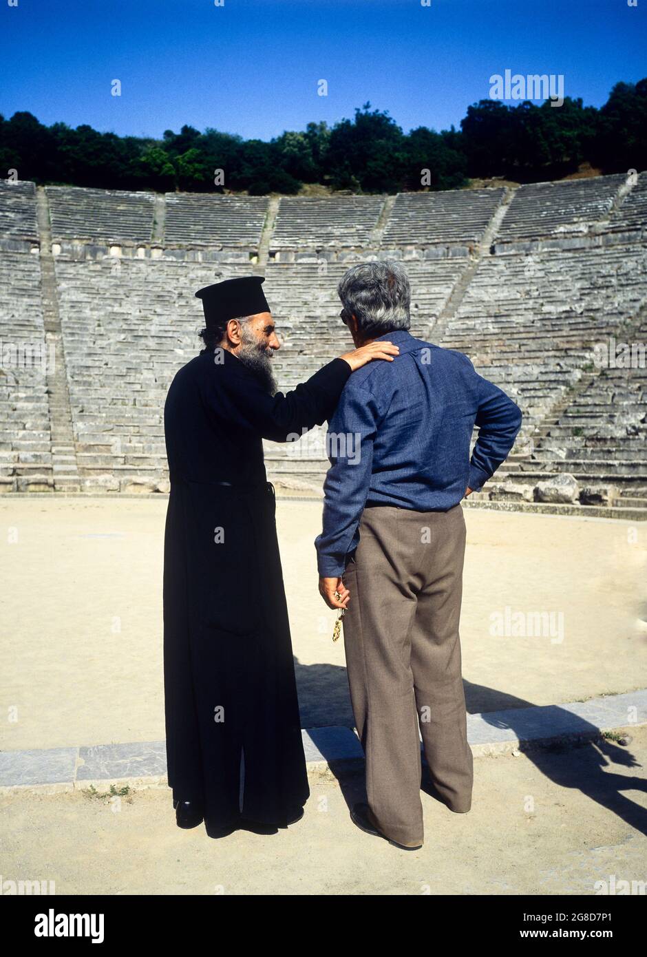 Orthodox priest chatting with man, Epidaurus Ancient Theatre, Argolis ...