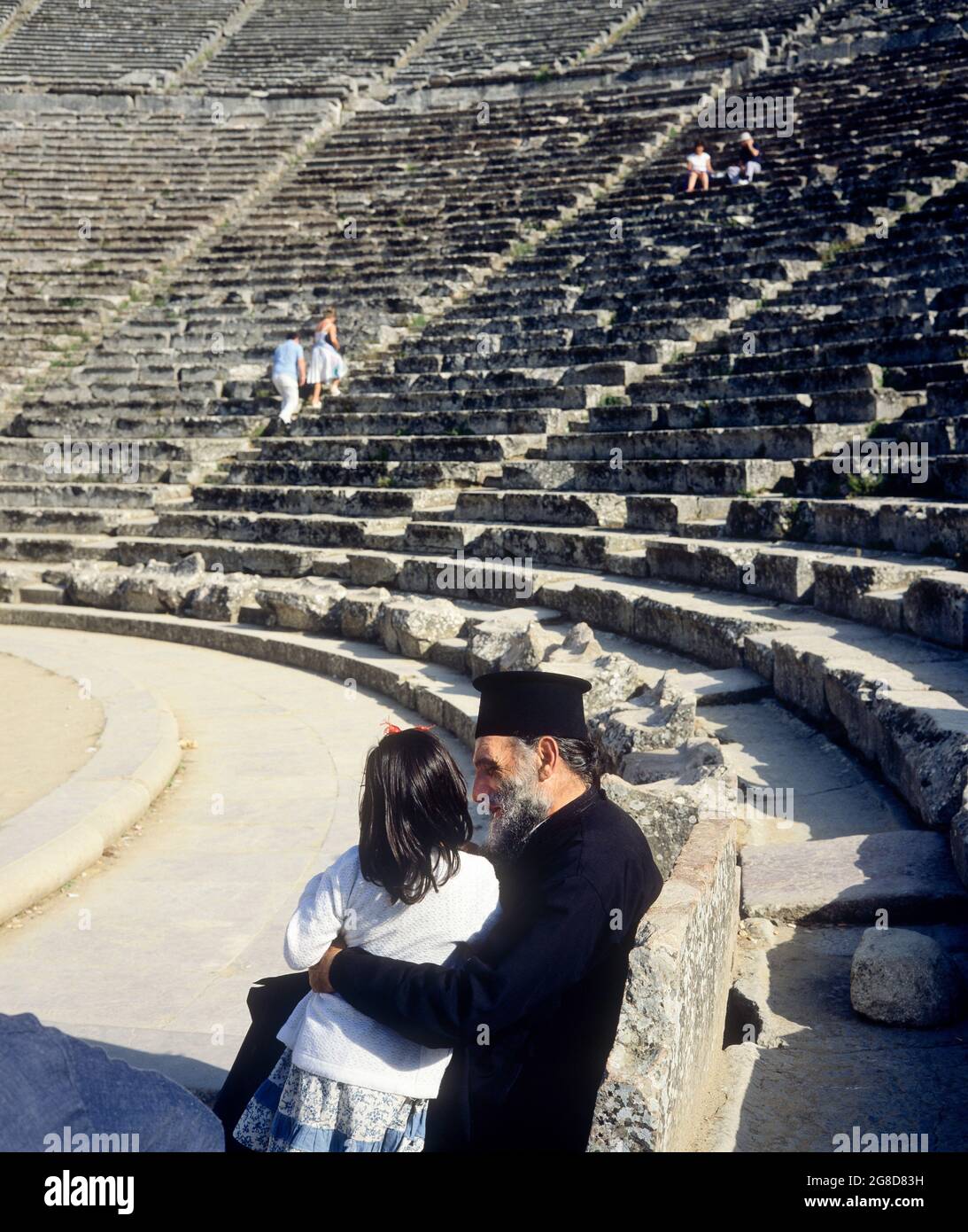 Orthodox priest cuddling a little girl, Epidaurus Ancient Theatre ...