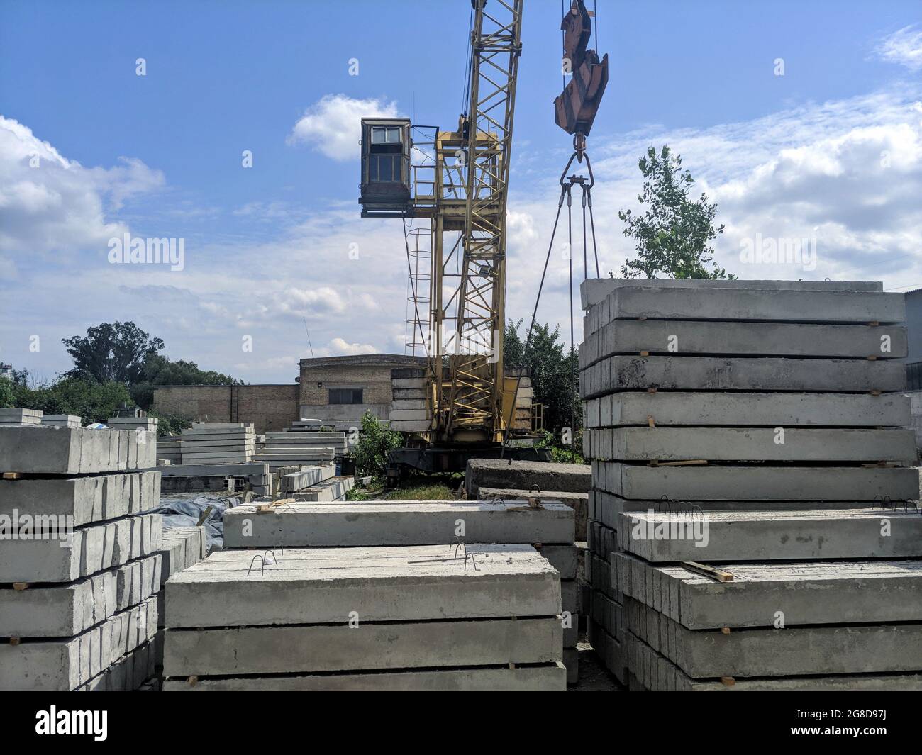 industrial crane loading up reinforced concrete block at warehouse ...