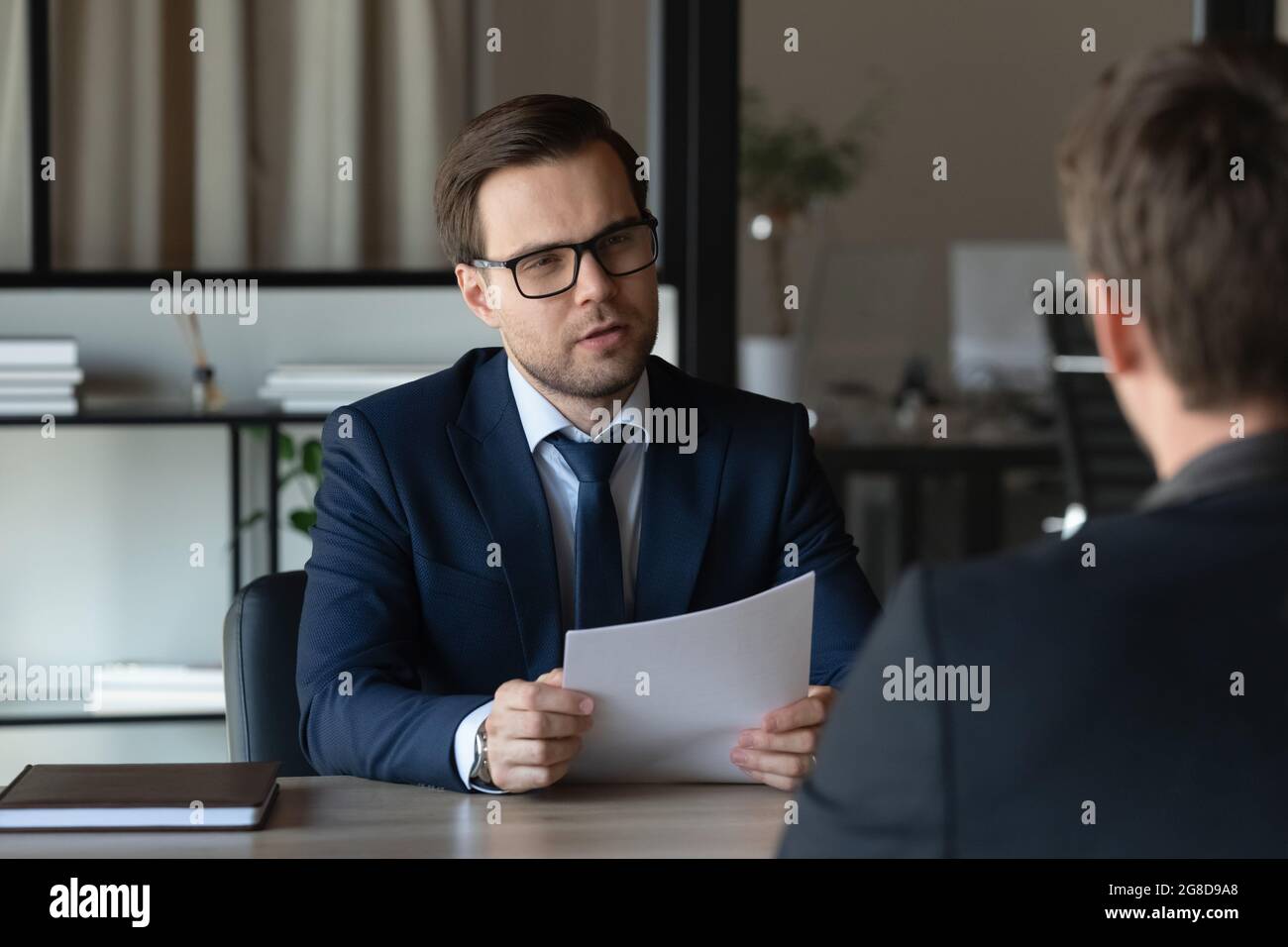 Serious concentrated employer with paper resume interviewing job ...