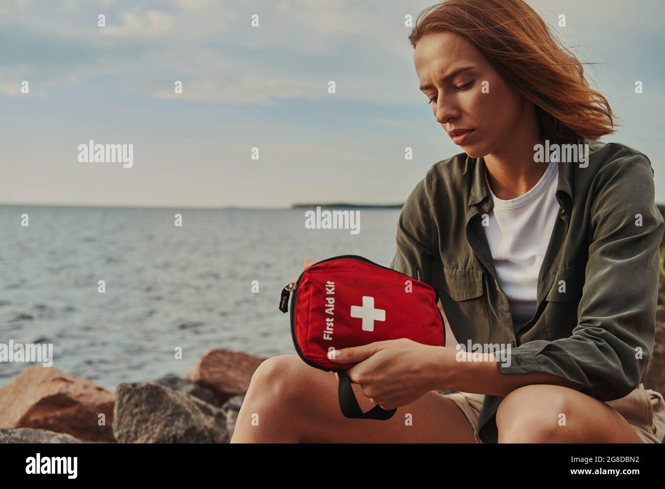 Tourist is sitting with first aid kit Stock Photo - Alamy