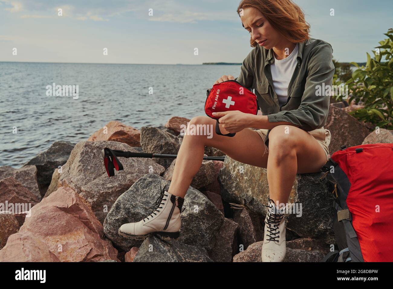 Fit female reaching inside first aid kit Stock Photo - Alamy