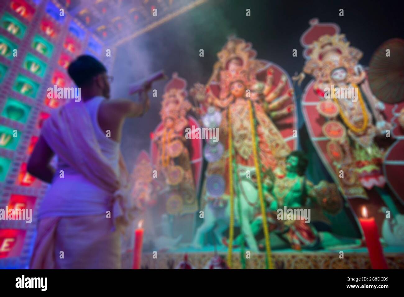 Blurred image of Hindu Bengali priest worshipping Goddess Durga with ...