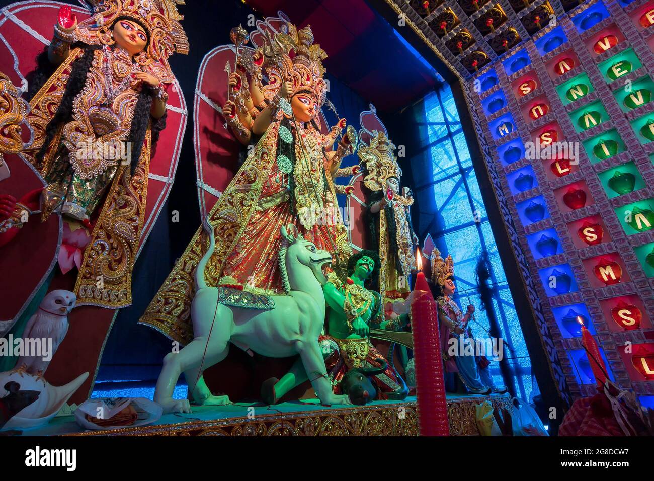 Holy candle is lit inside decorated Durga Puja pandal with out of focus ...