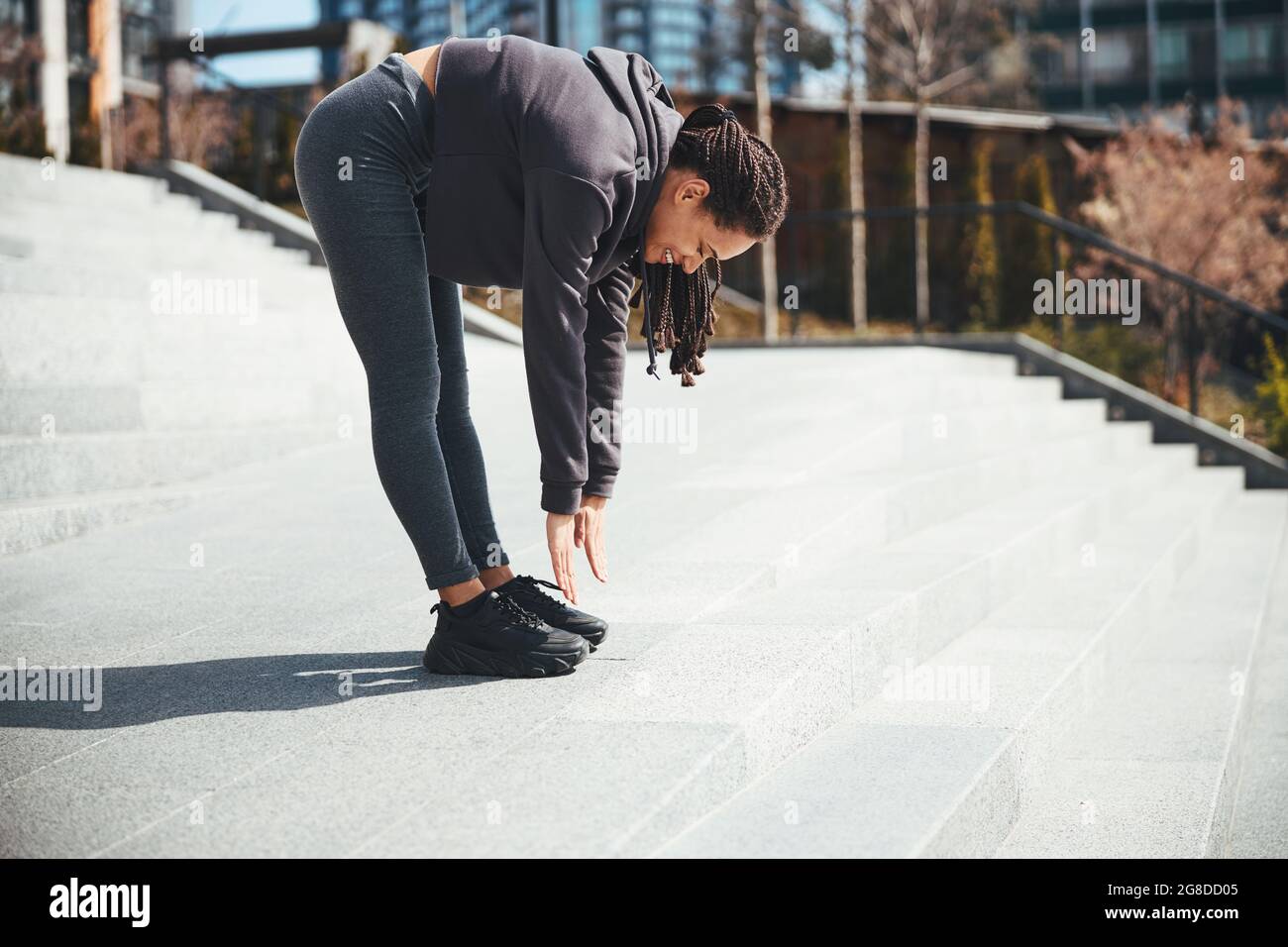 Joyous athlete performing a forward bend outside Stock Photo - Alamy