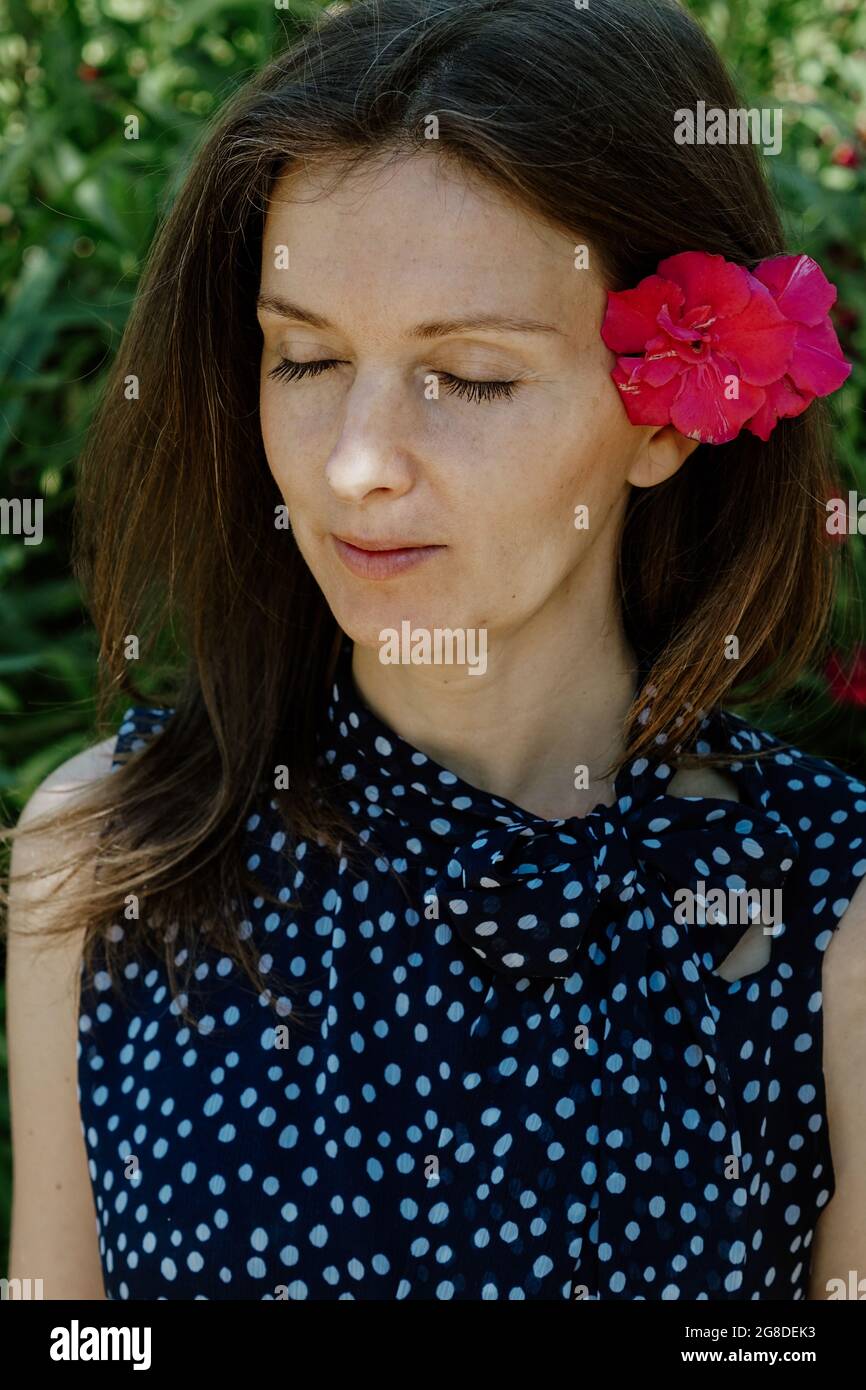 Portrait of a Spanish lady with a flower in her hair, enjoying the ...