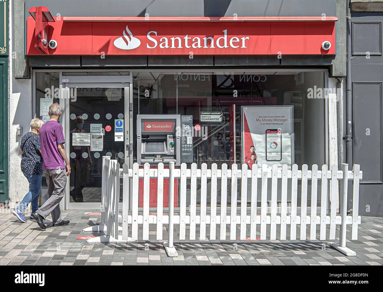 Lisburn, UK. 19th July, 2021. An older couple enters Santander Bank on ...