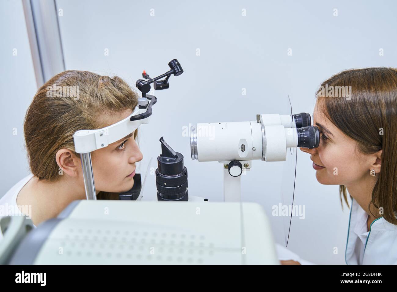 Female doctor examining woman eyes with ophthalmic equipment Stock ...