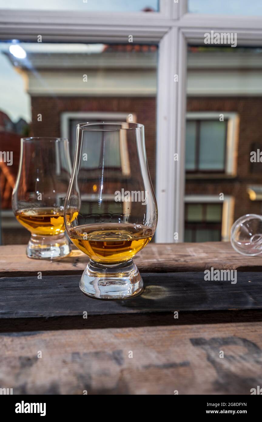 Dram of single malt scotch whisky served in tasting glass with view on ...