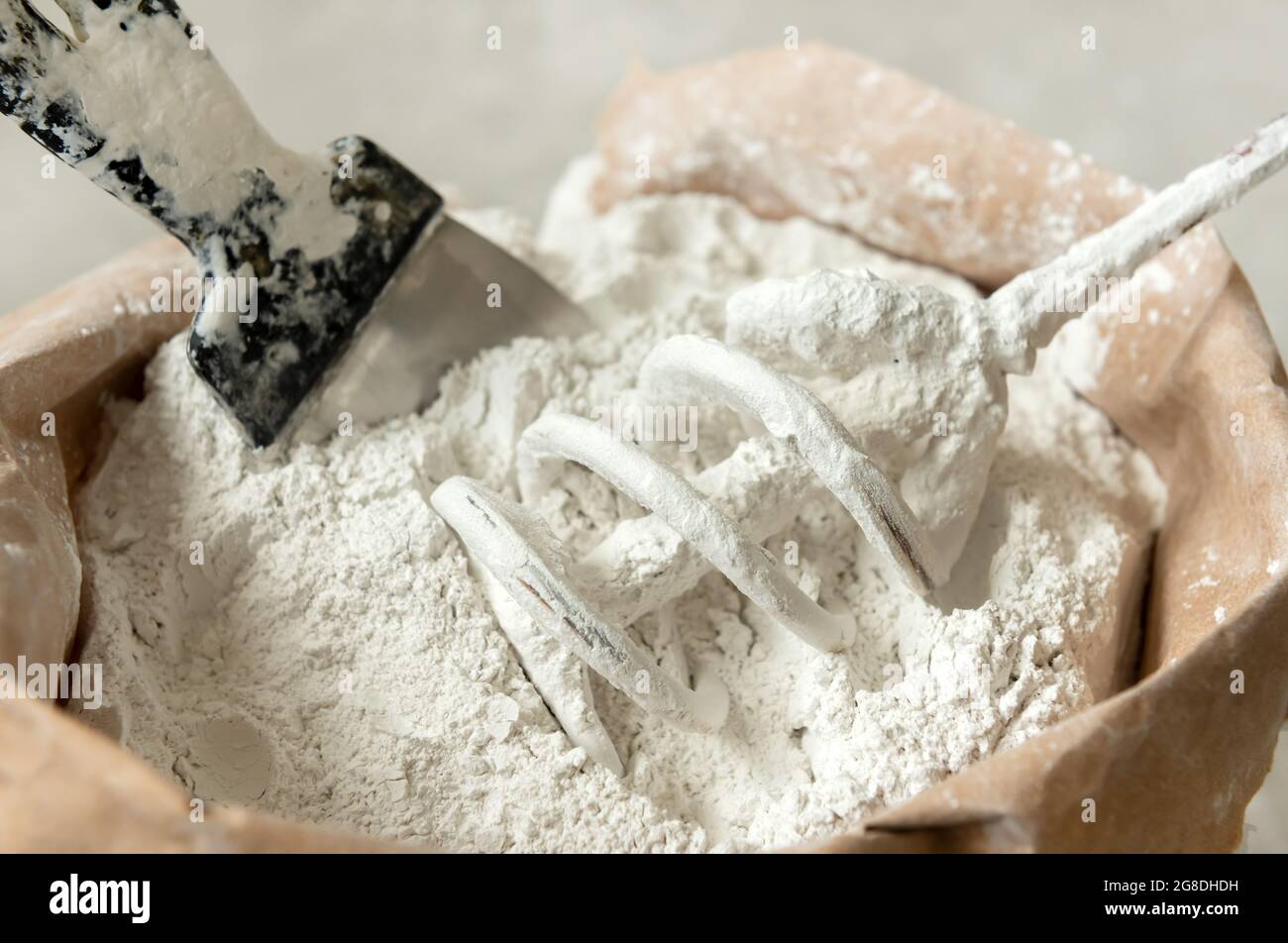 Putty. A spatula. Hand-held mixer . A bag with putty and a mixer for ...