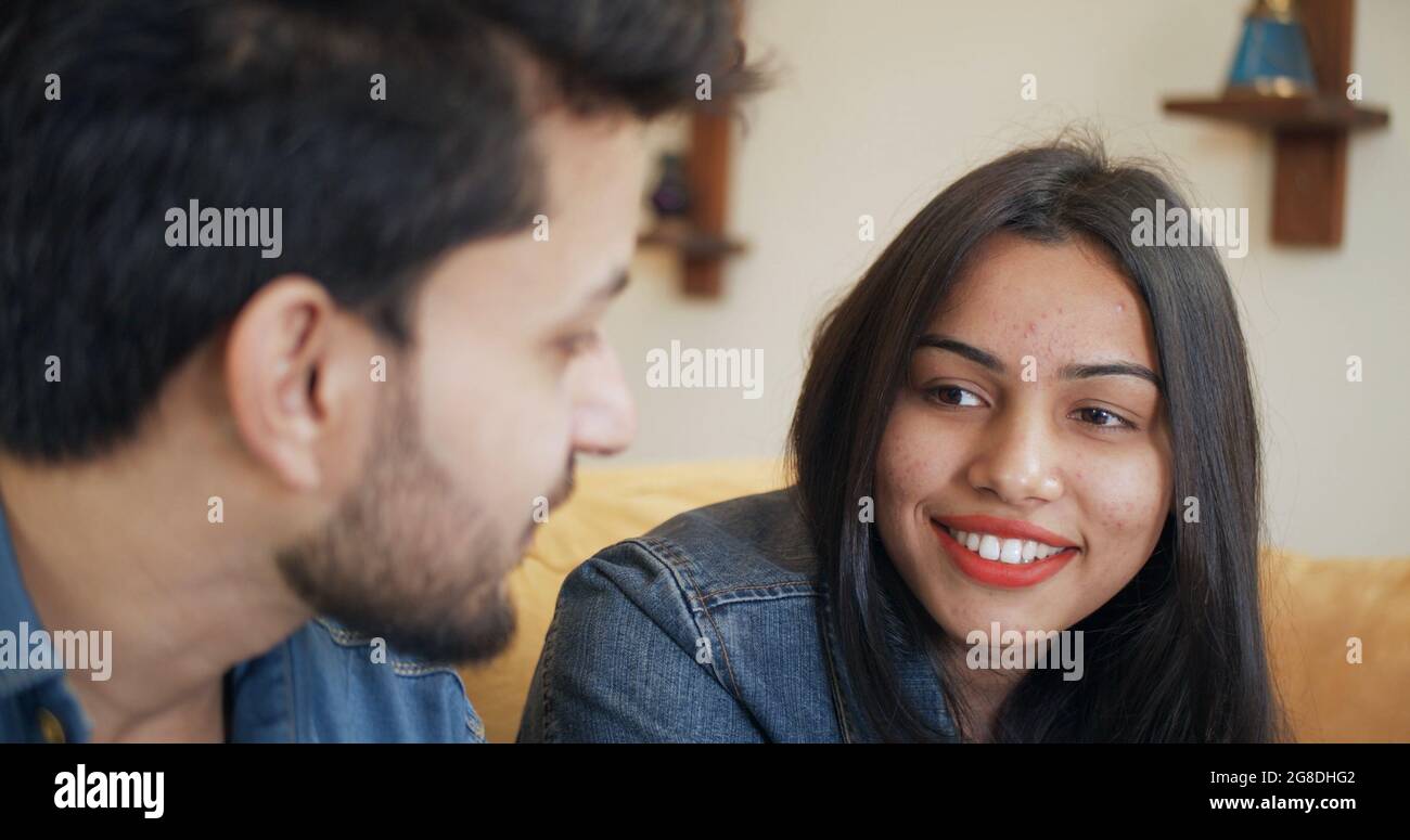 Young Indian couple happily chatting while sitting on the sofa Stock ...