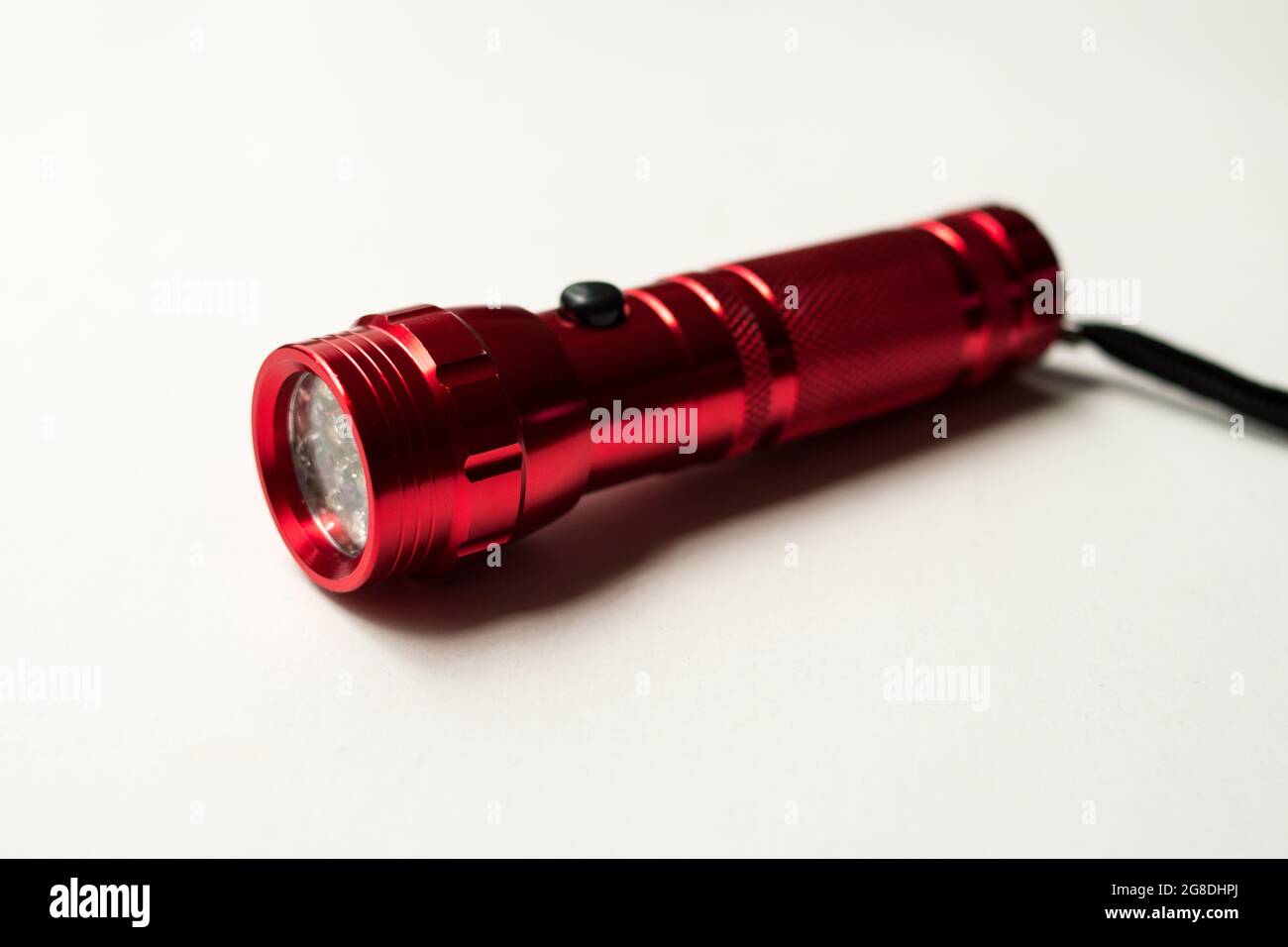 Closeup of a red LED mini flashlight isolated in the white background ...