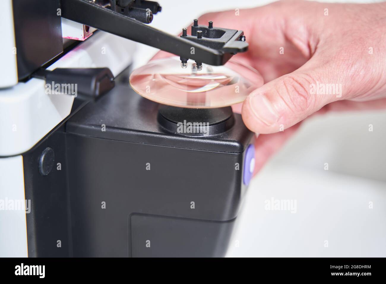 Male optician using modern optical equipment in workshop Stock Photo ...