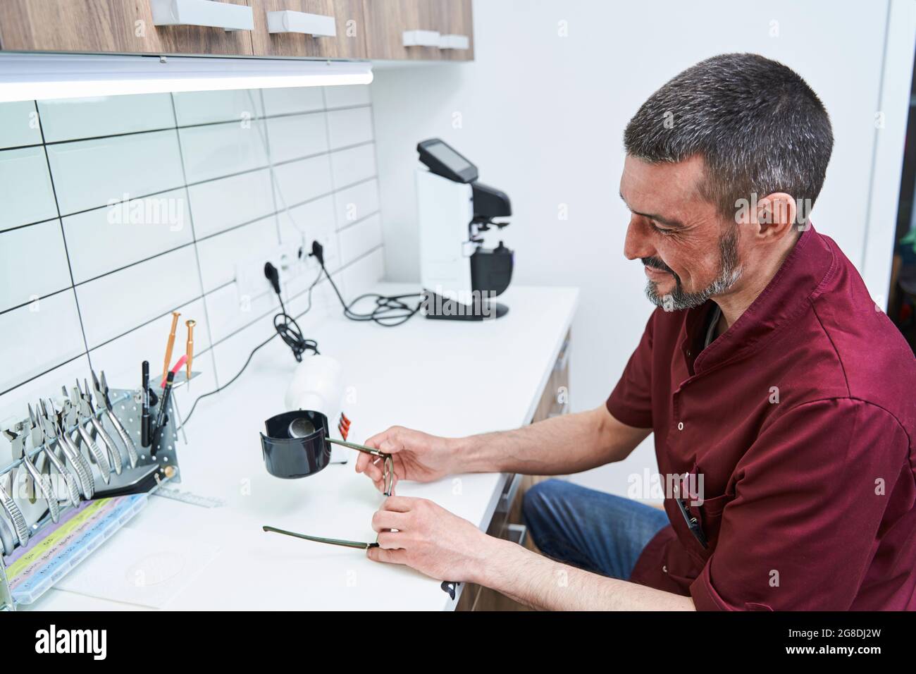 Bearded male optician with glasses working in optical workshop Stock ...