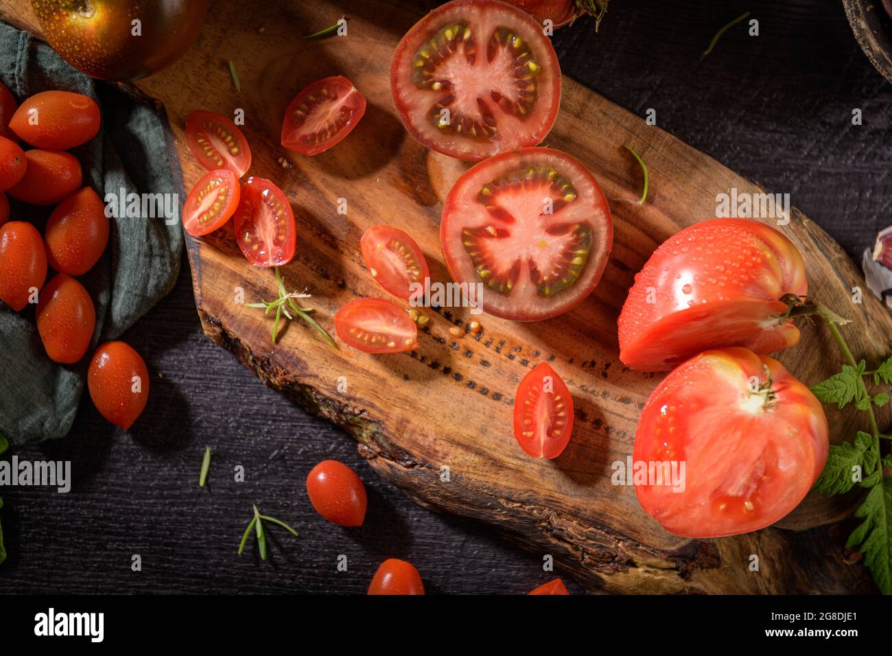 Large variety of tomatoes on rustic kitchen counter. Preparation of ...