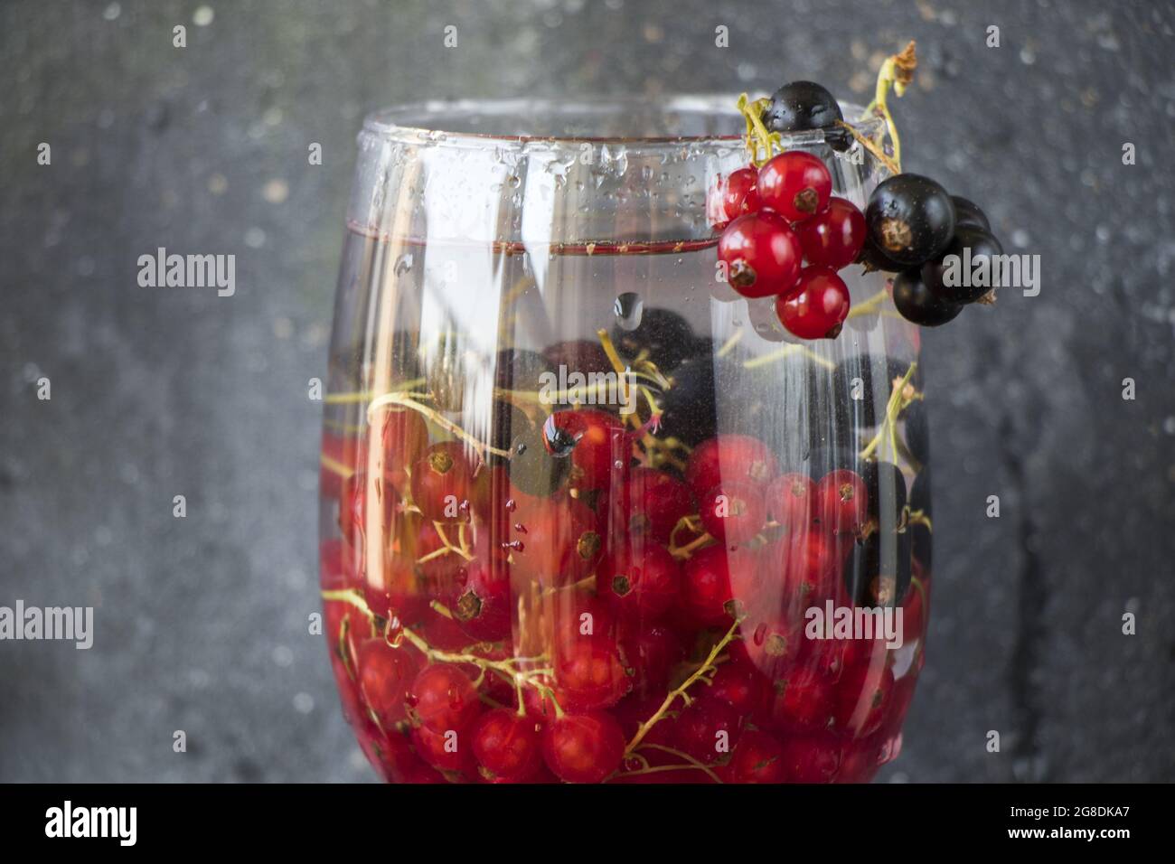 Red and black currants in a wine glass on a gray background Stock Photo ...