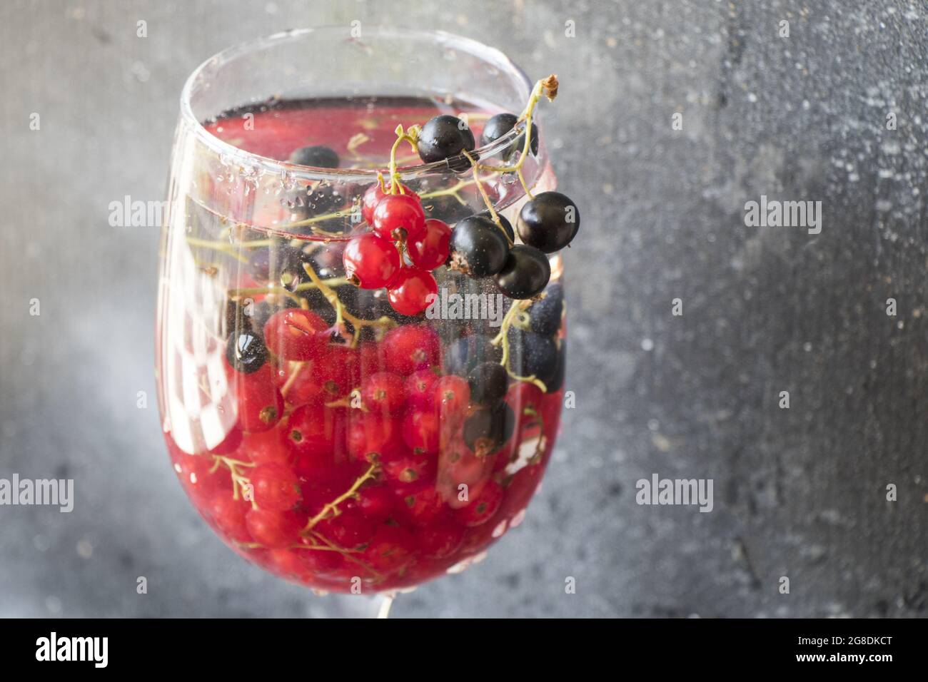 Red and black currants in a wine glass on a gray background Stock Photo ...